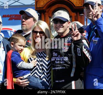 Johnny Sauter holds his son, Penn, as his wife, Cortney, left, joins ...