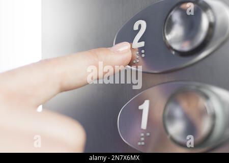 Hand touching elevator braille figure 1 Stock Photo - Alamy