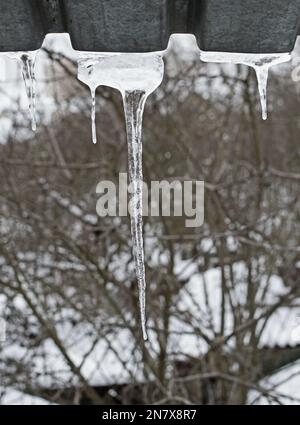 Icicles of various shapes hang from the metal roof. Selective focus ...