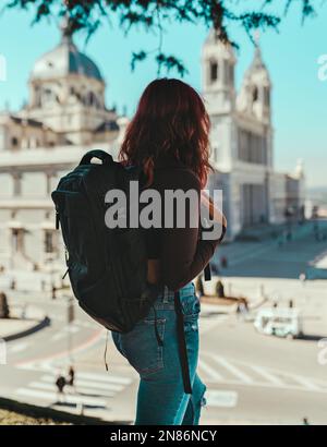 Young beautiful woman wearing backpack using headphones over isolated ...
