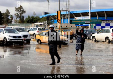 Iraqi traffic police officers control traffic in front of election ...
