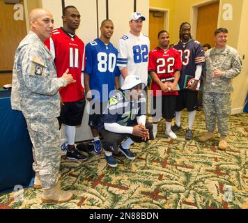 Seattle Seahawks' Marshawn Lynch autographs necklaces during a charity ...