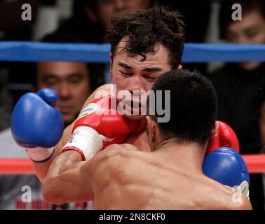 Costa Rican challenger Bryan Vasquez, right, gets a punch by Japanese champion Takashi Uchiyama ...
