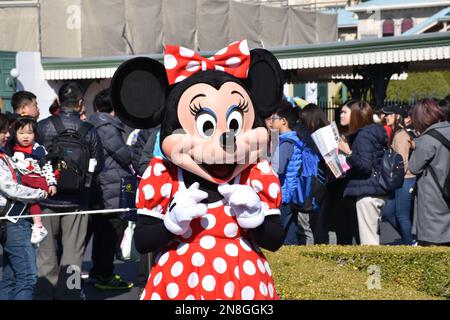 A cute Minnie Mouse at Tokyo Disney land with people in the background ...