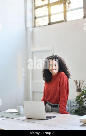 Portrait of young successful businesswoman at office. She sits at the ...