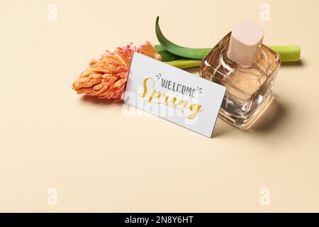 Card with text WELCOME SPRING, bottle of perfume and hyacinth flower on ...