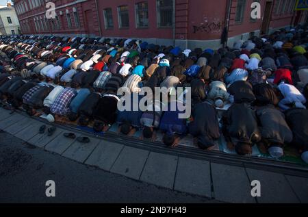 Muslim men, bowing toward Mecca, prepare to perform Eid al-Fitr prayers ...