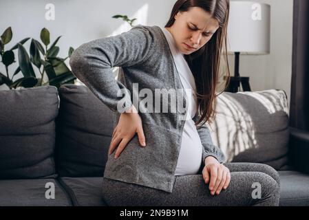 woman holding back while and suffer from unbearable pain health and ...