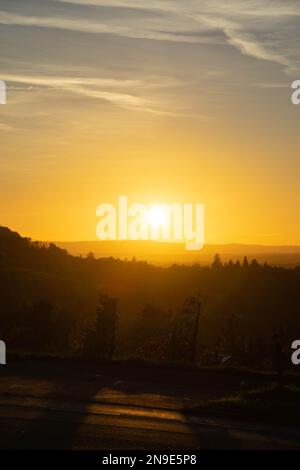 Golden Sun Setting Over Countryside Hills Framed by Trees in Rural ...