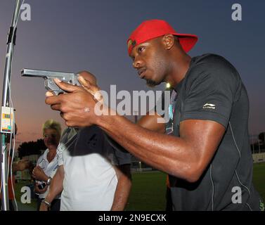 Jamaican sprinter Asafa Powell fires the starting gun for a race in ...