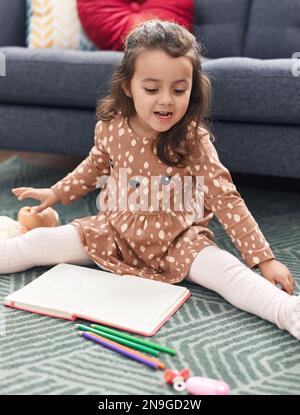 Adorable hispanic toddler reading book standing at bedroom Stock Photo ...