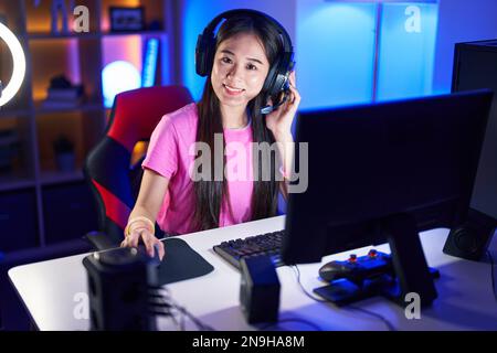 Young chinese woman streamer smiling confident sitting with arms ...