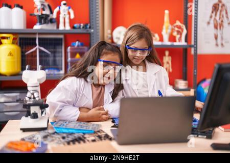 Two kids students using laptop and touchpad studying at classroom Stock ...