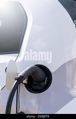 Close-up power supply connected to an electric car to add a charge to ...