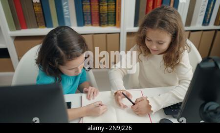 Adorable hispanic boy student writing on notebook holding molecules at ...