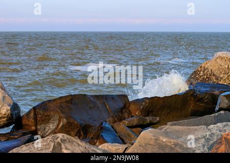 Wind blown waves hit the boulders along the wintery shoreline of Lake ...
