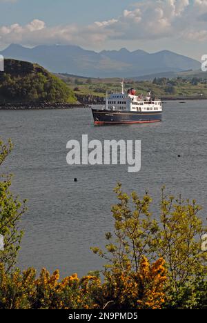 HEBRIDEAN PRINCESS underway in PORTREE BAY, with the dramatic backdrop ...