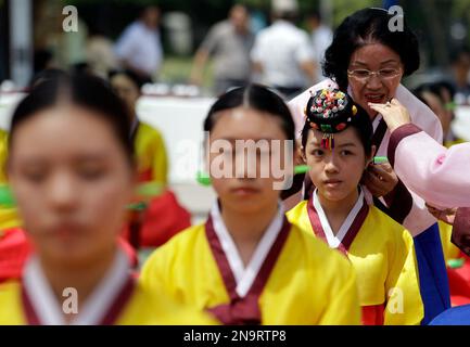 Two women assist a girl at the 40th Coming of Age Day ceremony, known ...