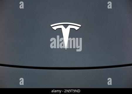 The Tesla logo insignia badge on the bonnet of an EV vehicle at a ...