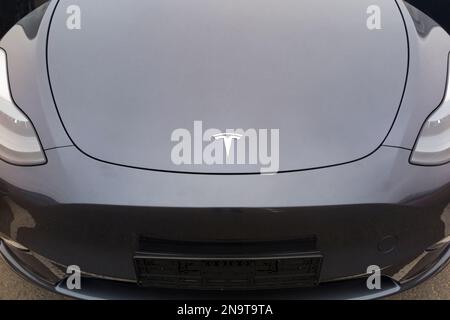 The Tesla logo insignia badge on the bonnet of an EV vehicle at a ...