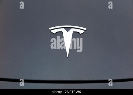 The Tesla logo insignia badge on the bonnet of an EV vehicle at a ...