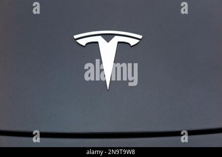 The Tesla logo insignia badge on the bonnet of an EV vehicle at a ...