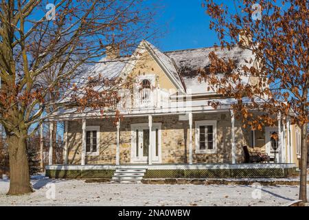 Old 1820 cottage style fieldstone house facade with beige wood plank ...