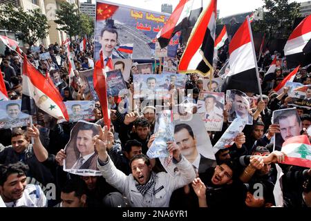 Syrian Baath Party supporters chant slogans, as they carry Syrian flags ...