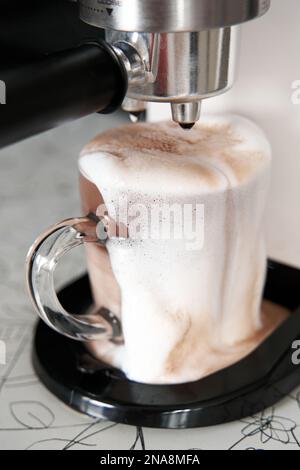 Coffee machine overfilled cup with coffee close up Stock Photo - Alamy