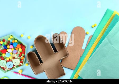 Cardboard cactus and materials on light blue background, flat lay ...
