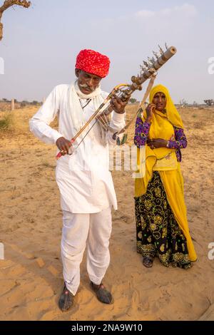 Rajput man playing ravanahatha and woman singer performing at festival ...