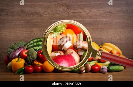 Magnifying glass focusing on vegetables, closeup. Food control Stock ...
