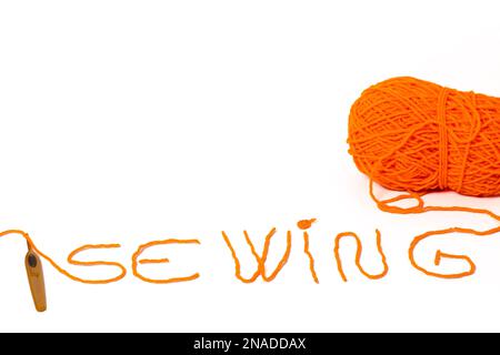 word sewing written with orange colored wool isolated on black ...
