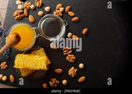 Honeycomb on slate tray with honey and nuts on kitchen table Stock ...