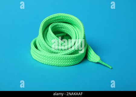 Mint shoe lace on light blue background Stock Photo - Alamy