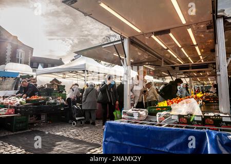 Picture of stalls of Vaals Farmers market iwith crowd of people passing ...