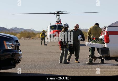 Clark County Coroner Michael Murphy takes what appear to be flowers ...