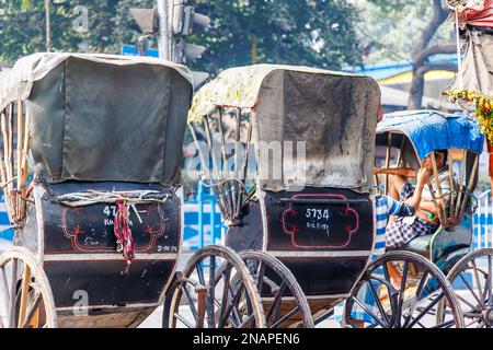 Traditional vintage wooden rickshaws parked in the street in Fariapukur ...