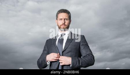 Portrait of grizzled guy sky background. Serious guy keeping arms ...