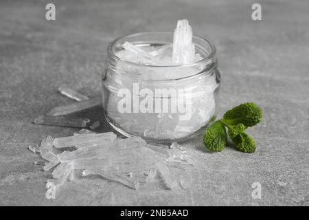 Menthol crystals and fresh mint leaves in bowl on white background ...