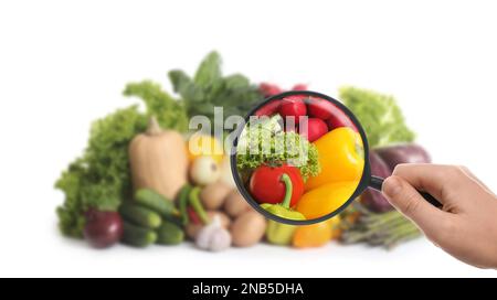 Woman with magnifying glass exploring vegetables and fruits, closeup ...