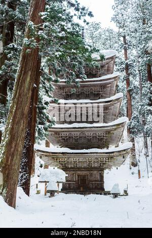 The five-storied pagoda in a forest of cedar trees with deep snow at ...