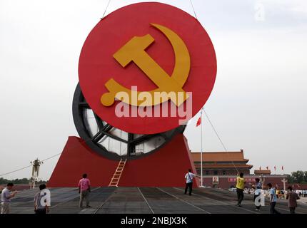 Chinese workers install a giant communist party symbol to celebrate the ...