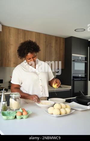 Young cuban woman breading mashed potatoes balls Stock Photo - Alamy