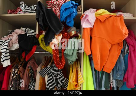 Messy wardrobe with different clothes. Fast fashion concept Stock Photo ...