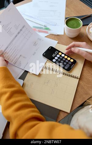 Top view of a businesswoman taking notes in notebook over office desk ...