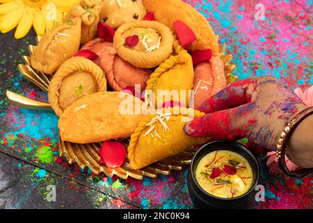Hands Of A Girl Painted With Colorful Gulal Holding Delicious Gujiya ...