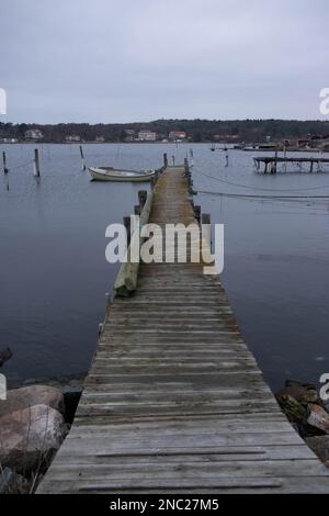 A vertical shot of a wooden dock under a beautiful Aurora Borealis ...