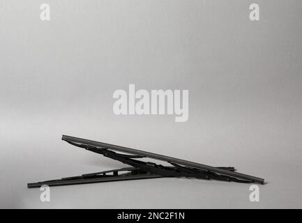 Car windshield wipers on grey stone background, flat lay. Space for ...
