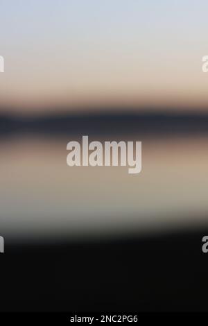 Blurry dreamy abstract vision of a lake during the morning sunrise in a ...